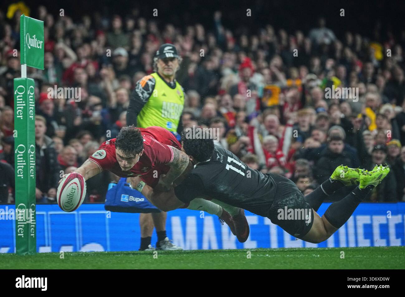 Wales' Louis Rees-Zammit dives over to score a try despite the ...