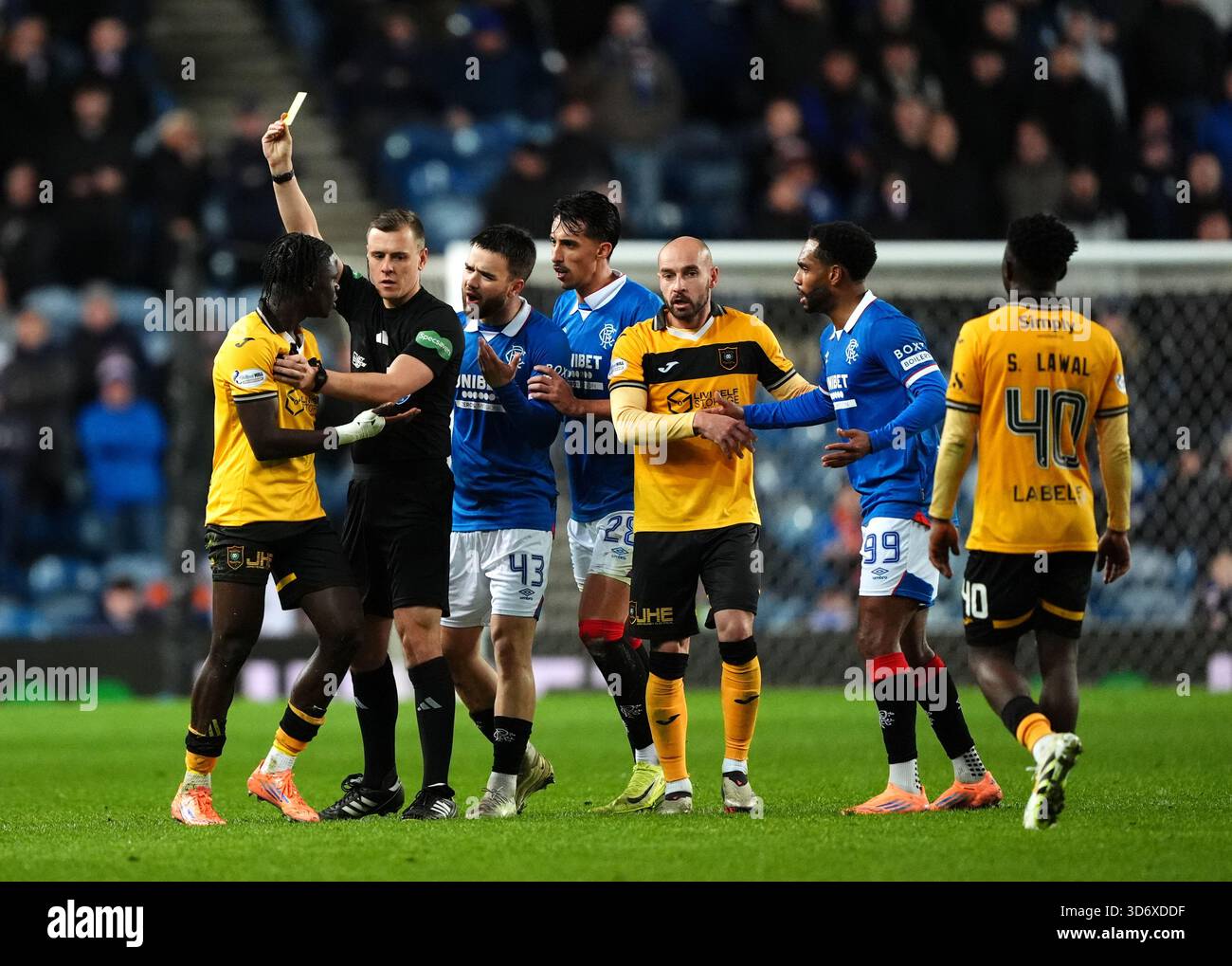 Referee Ross Hardie shows a yellow card to Livingston's Mahamadou ...