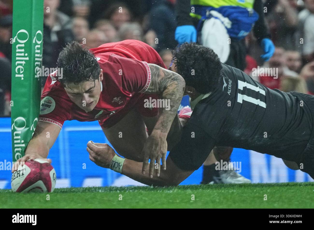 Wales' Louis Rees-Zammit dives over to score a try despite the ...
