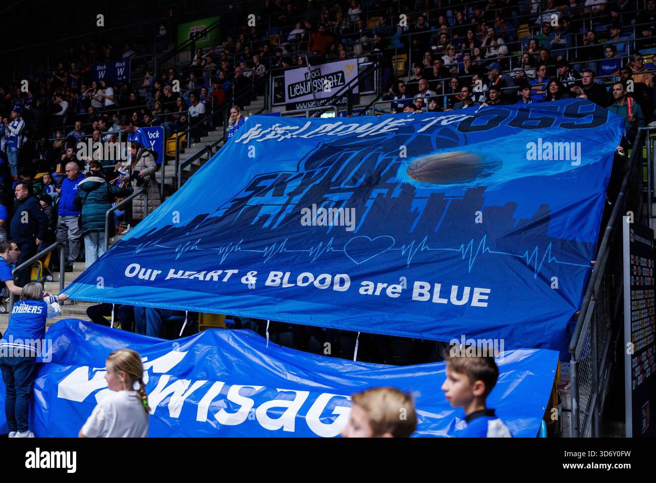 The fans [supporters] of the Skyliners are rolling out a large banner ...