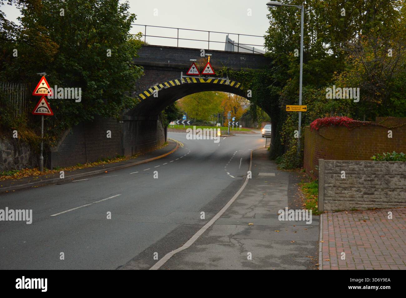 17,10,2025 Lichfield, UK, Brick railway bridge with warning signs and ...