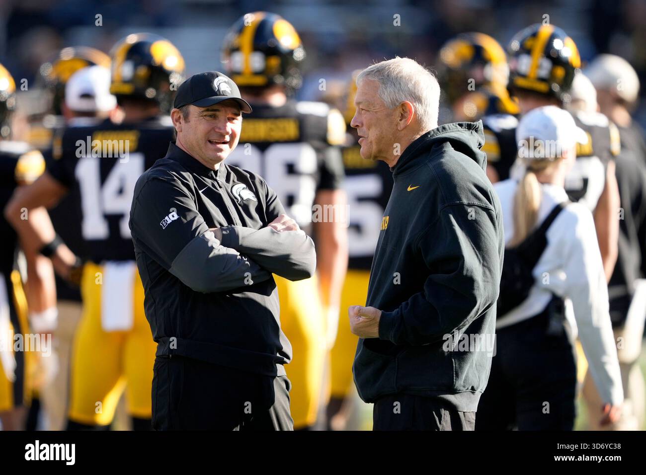 Michigan State head coach Jonathan Smith, left, talks with Iowa head ...