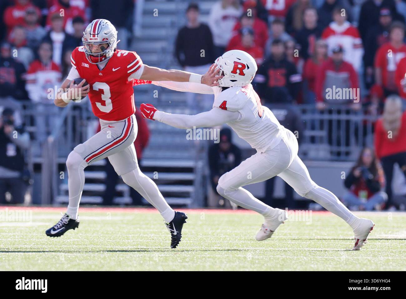 Ohio State quarterback Lincoln Kienholz, left, stiff arms Rutgers ...
