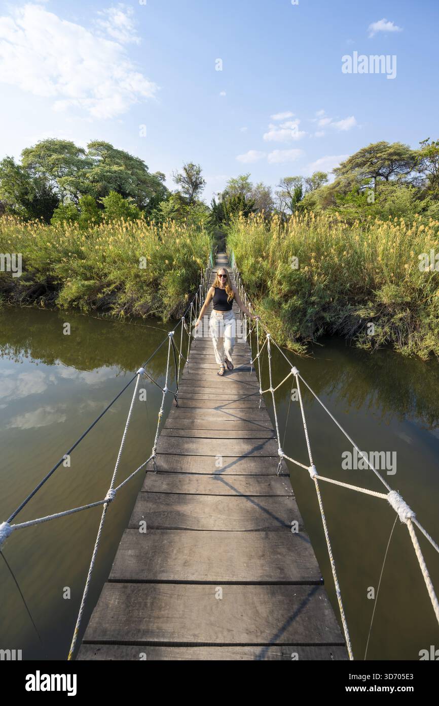 Toruist on the Kavango River, suspension bridge at Camp Kwando, Zambezi ...