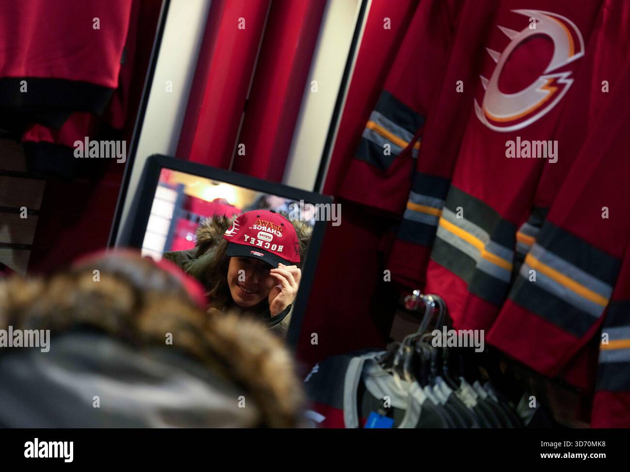 An Ottawa Charge fan checks out a hat in the mirror at the team store ...