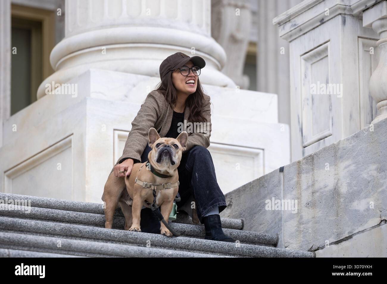 Rep. Alexandria Ocasio-Cortez (D-N.Y.) sits with her dog, Deco, outside ...