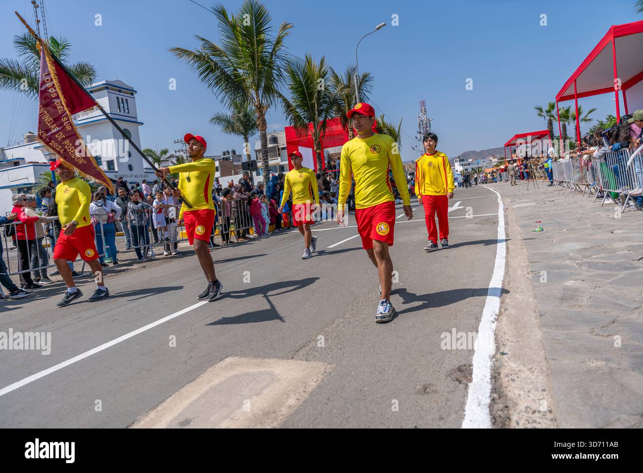 Institutional brigade marches in a civic parade wearing red and yellow ...