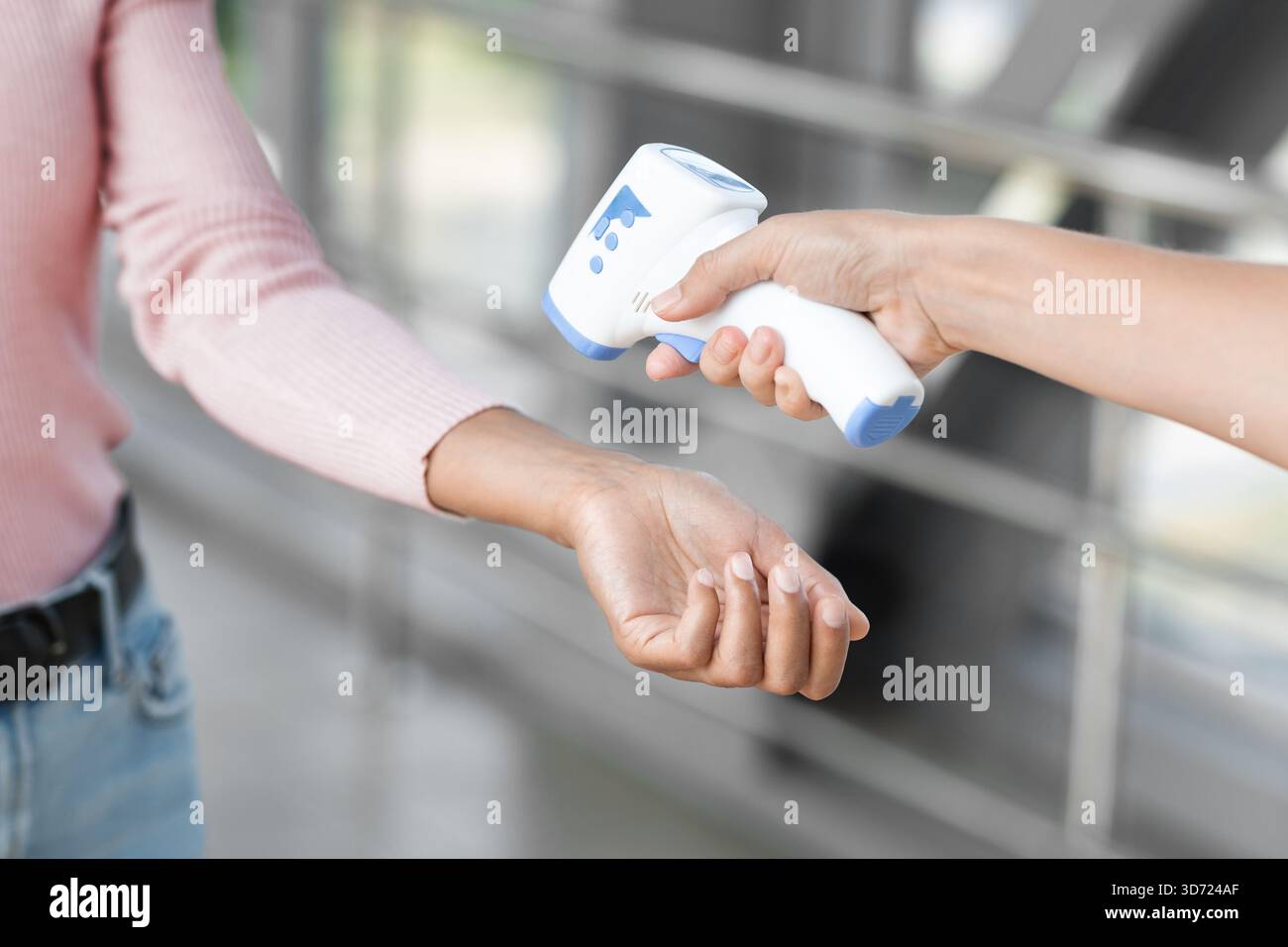 Person Receiving Temperature Check Inside a Modern Building During ...