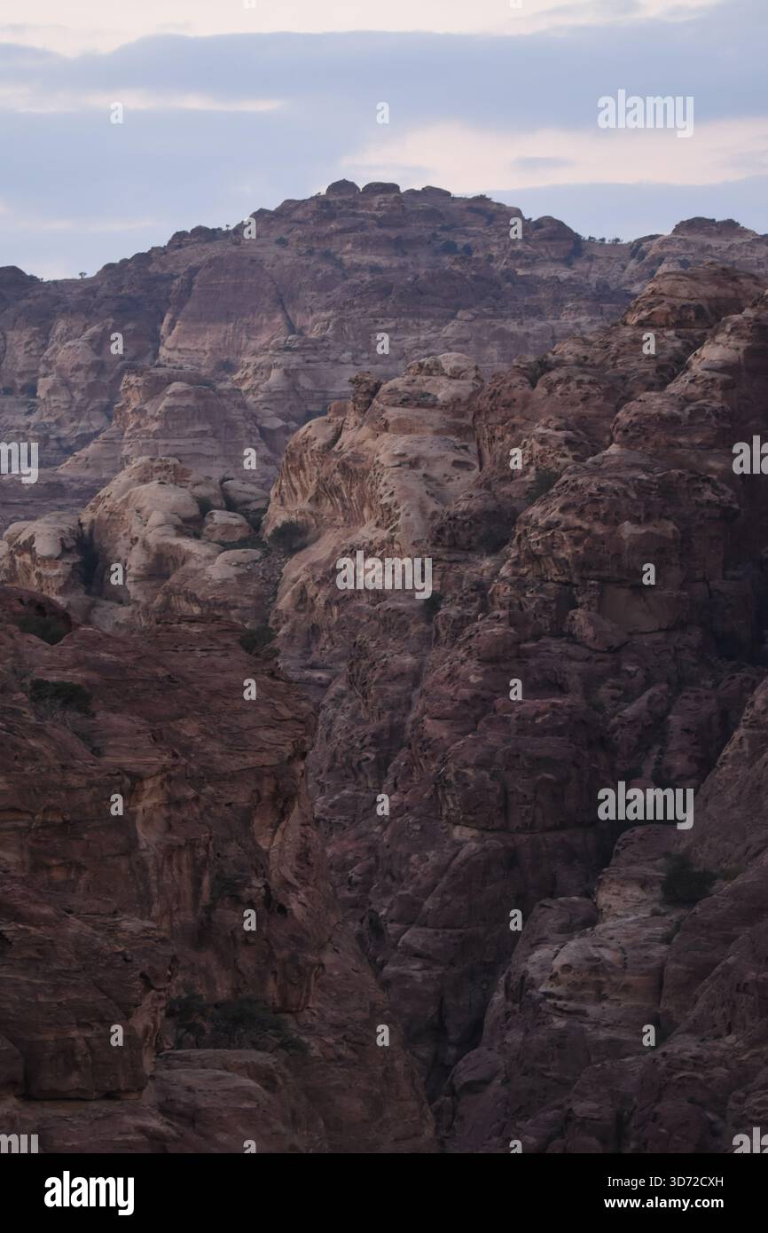 Rugged mountain formations stand tall in the fading light near Petra ...