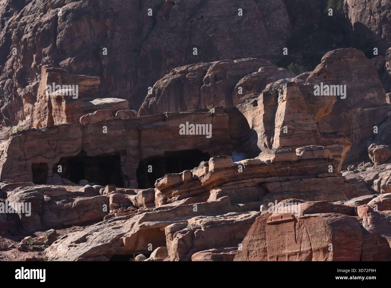 Visitors explore unique rock formations and caves in Petra, Jordan, as ...