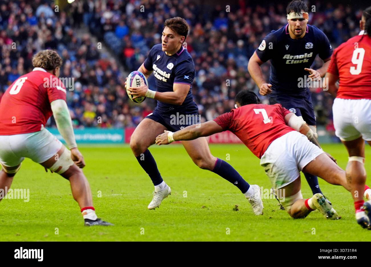 Scotland's Tom Jordan (centre) is tackled by Tonga's Siosiua Moala ...