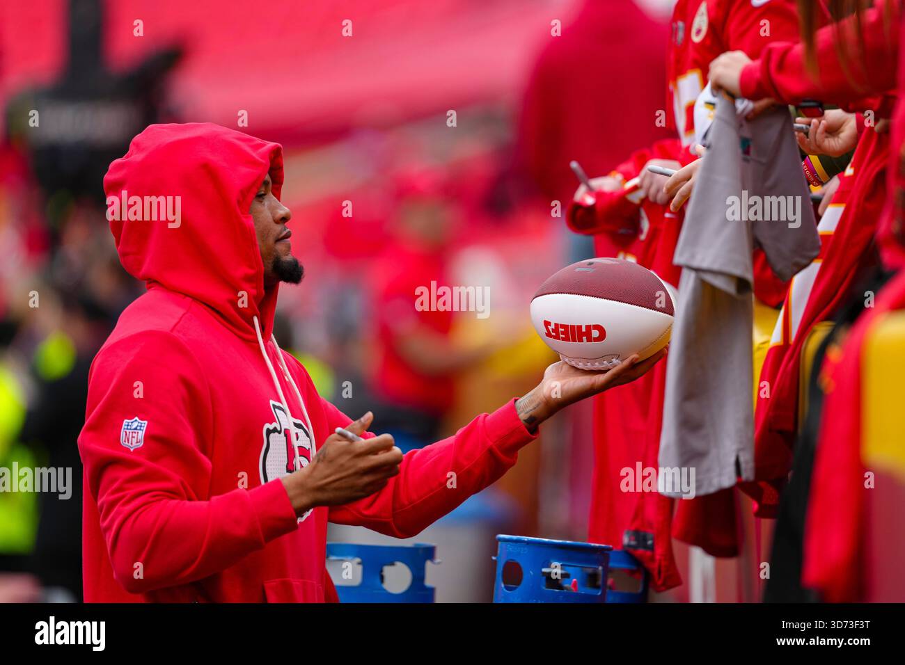 Kansas City Chiefs safety Bryan Cook (6) signs a football for a fan ...