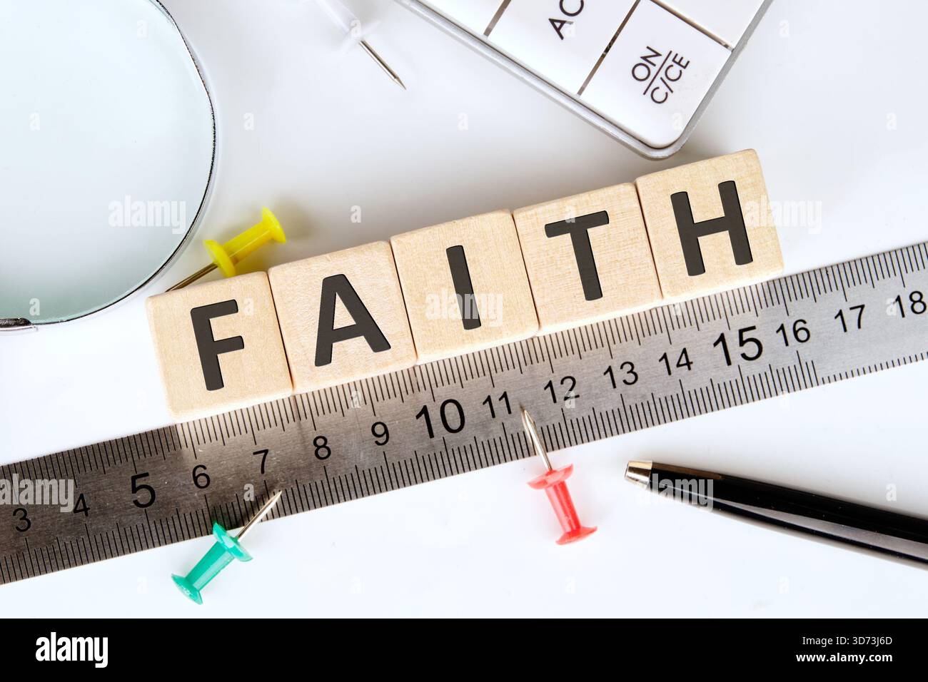 The word FAITH is spelled out using wooden blocks, resting beside a ...