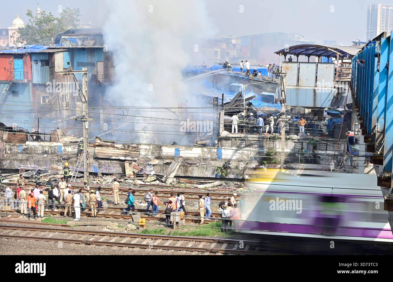 MUMBAI, INDIA - NOVEMBER 22: Railway commuters walk on track as the ...