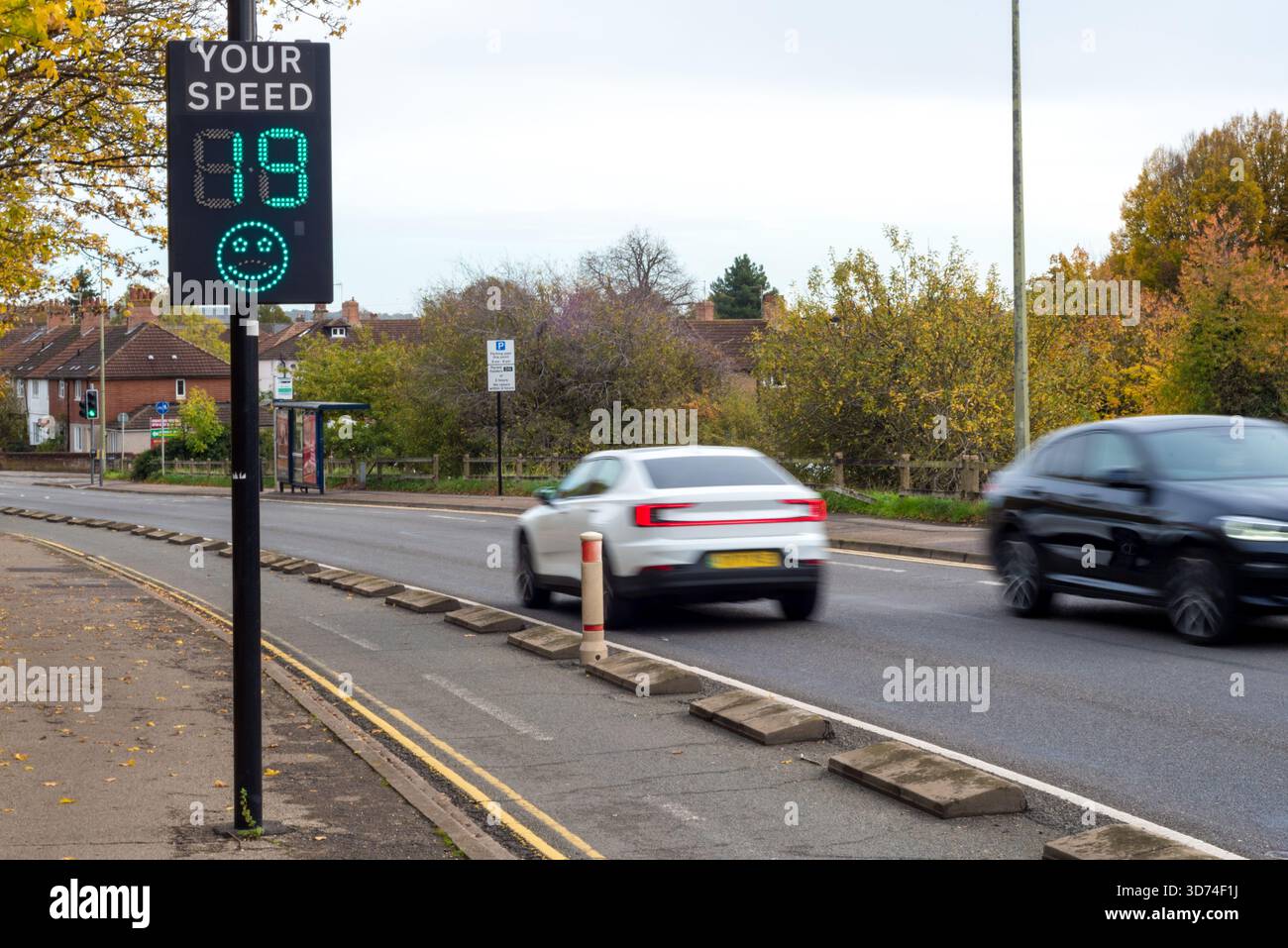 White car driving past a speed awareness sign on uk road Stock Photo ...