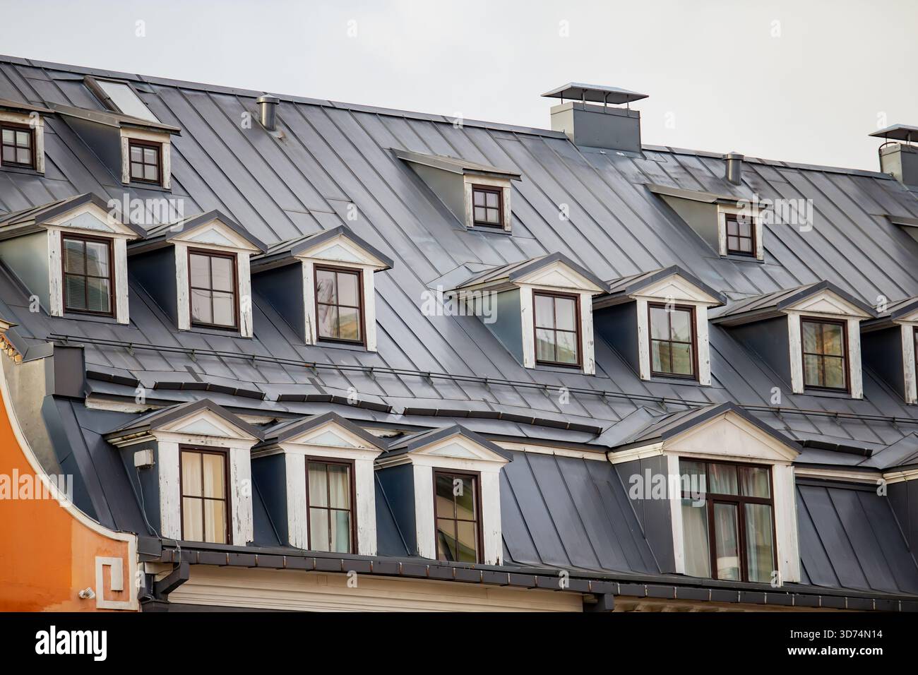 Building with metal roof featuring multiple dormer windows, small ...