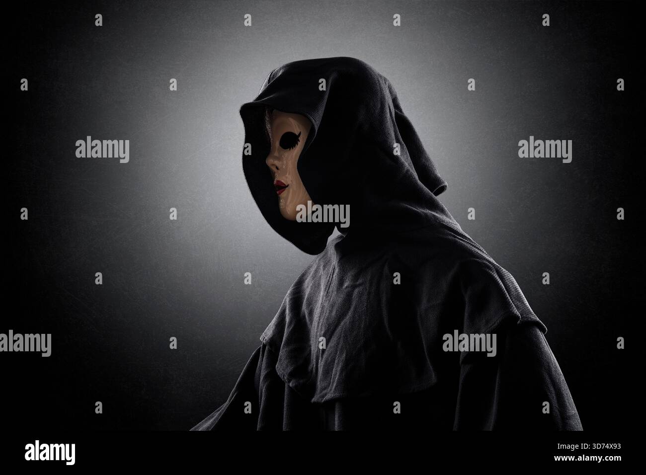 Scary lady with hooded cloak in the dark Stock Photo - Alamy