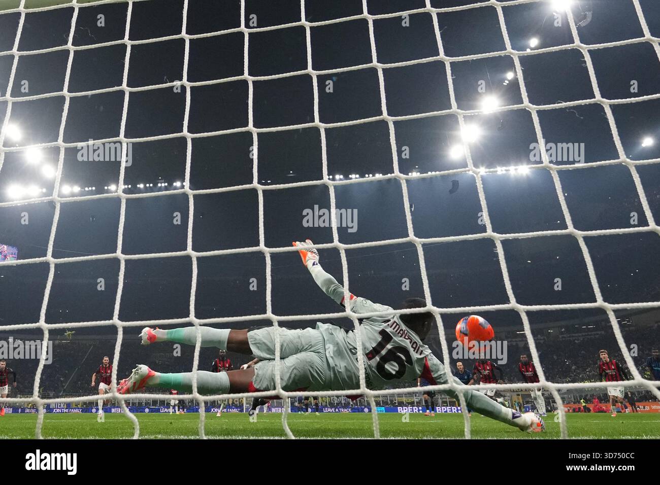 AC Milan's goalkeeper Mike Maignan saves a penalty kick during the ...