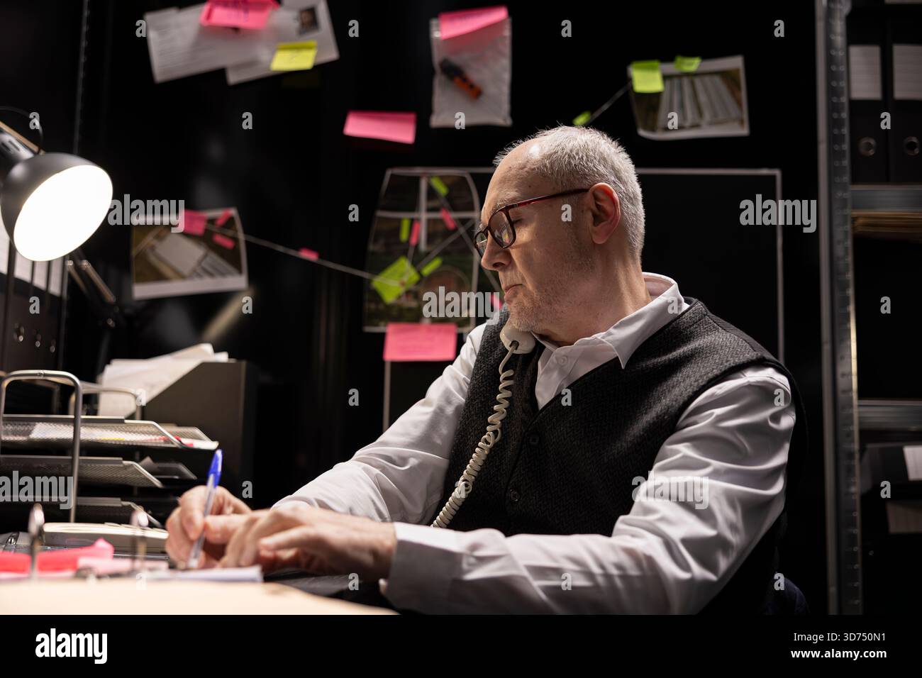 Senior detective communicates by landline phone in an evidence room ...