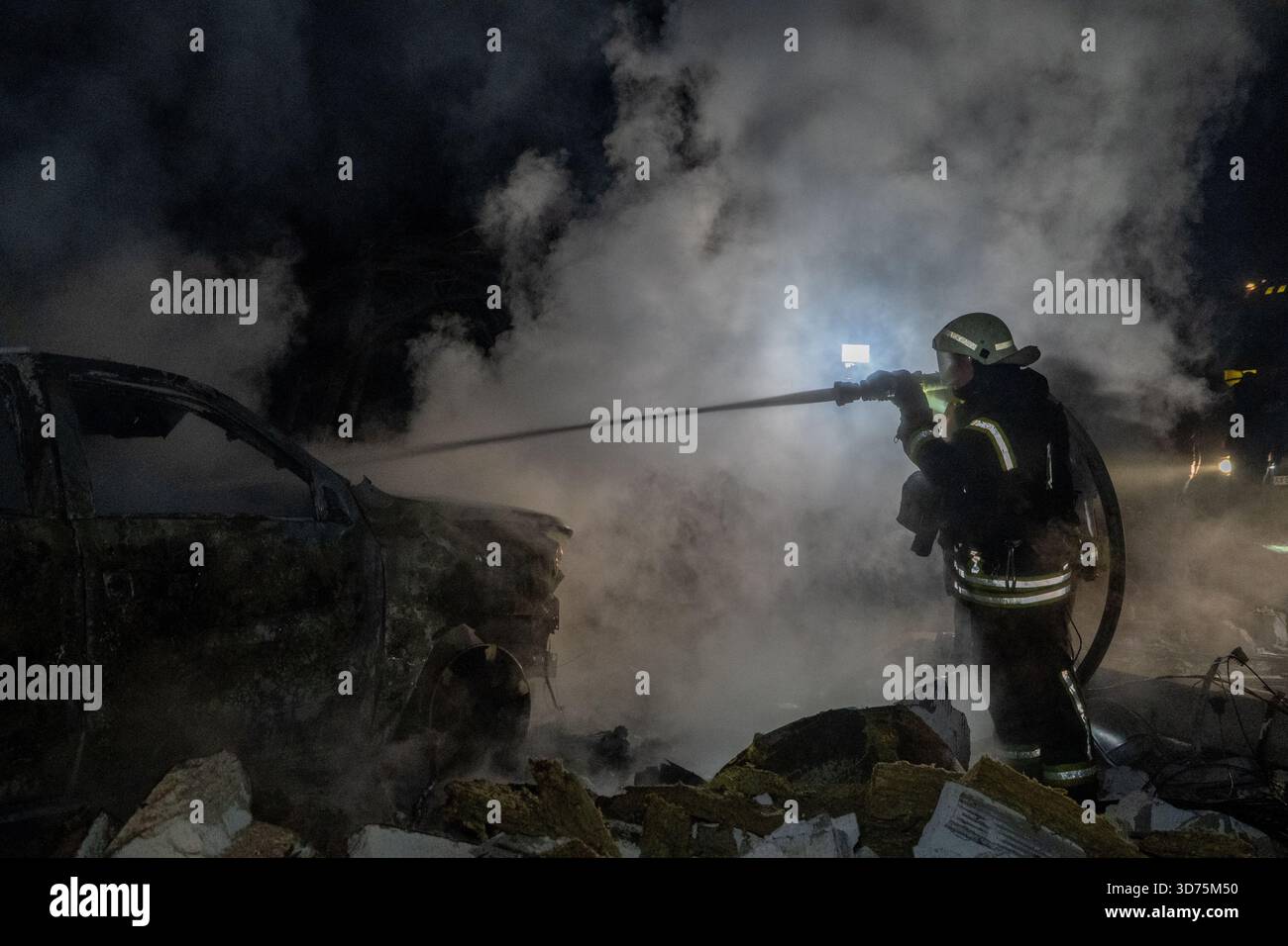 Rescue workers put out a fire of a residential building damaged by a ...