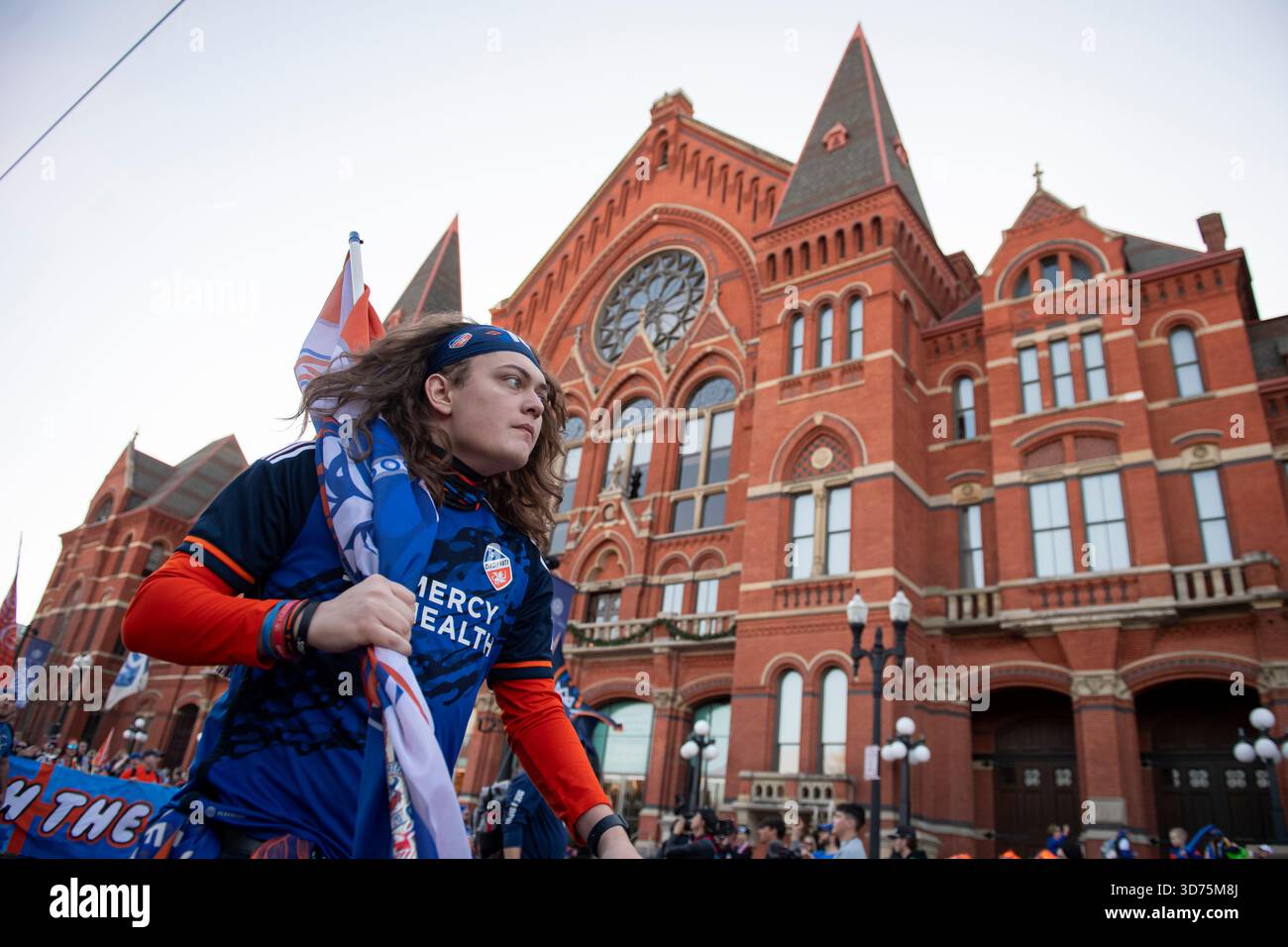 An FC Cincinnati fan walks with a flag along Elm St. in Cincinnati ...
