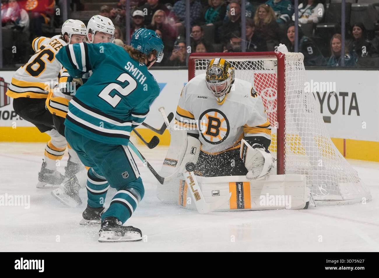 Boston Bruins goaltender Jeremy Swayman, right, defends against a shot by San Jose Sharks center ...