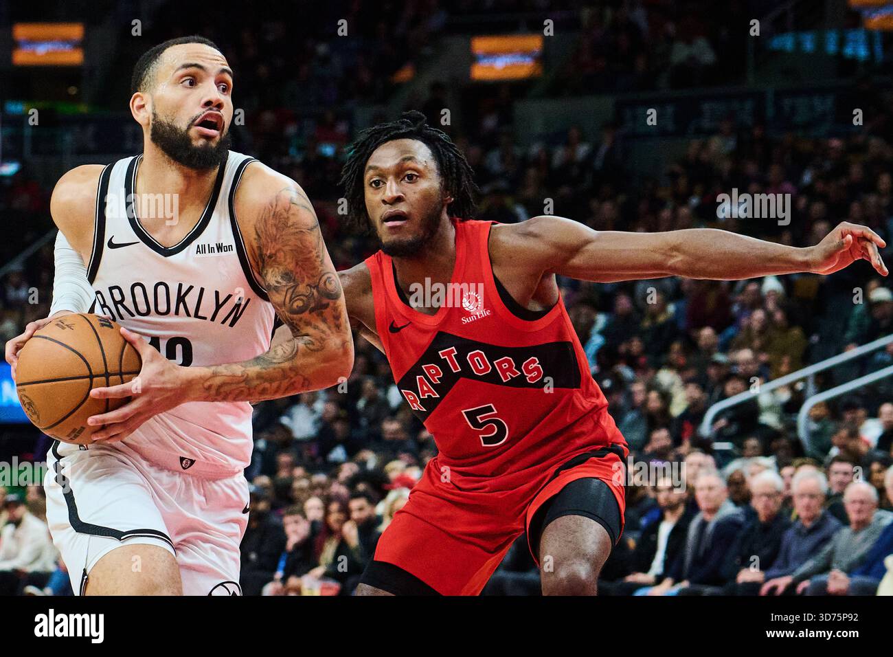 Brooklyn Nets' Tyrese Martin (13) drives past Toronto Raptors' Immanuel ...
