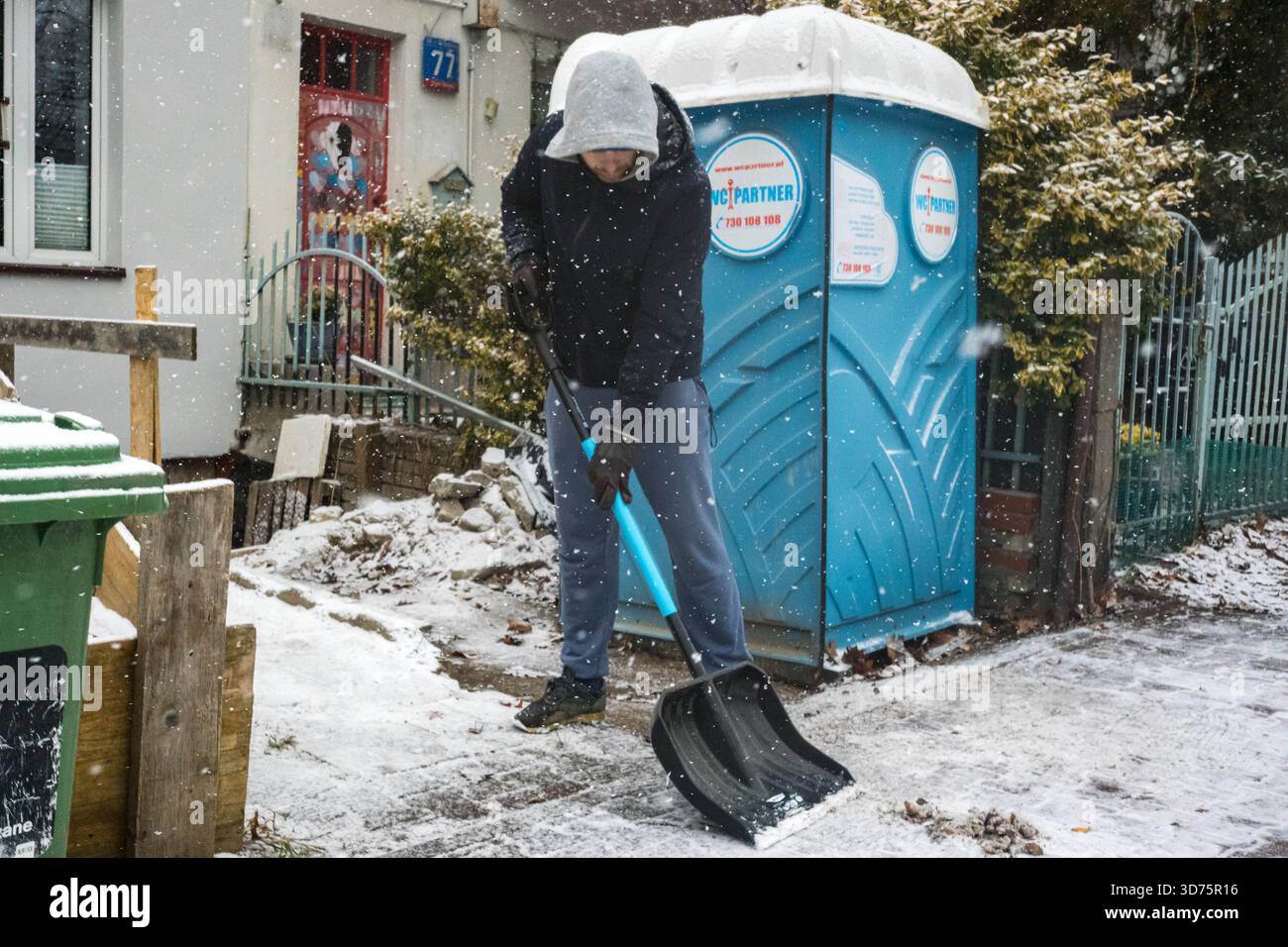 A homeowner clears the snow from the front of his garden. On the ...