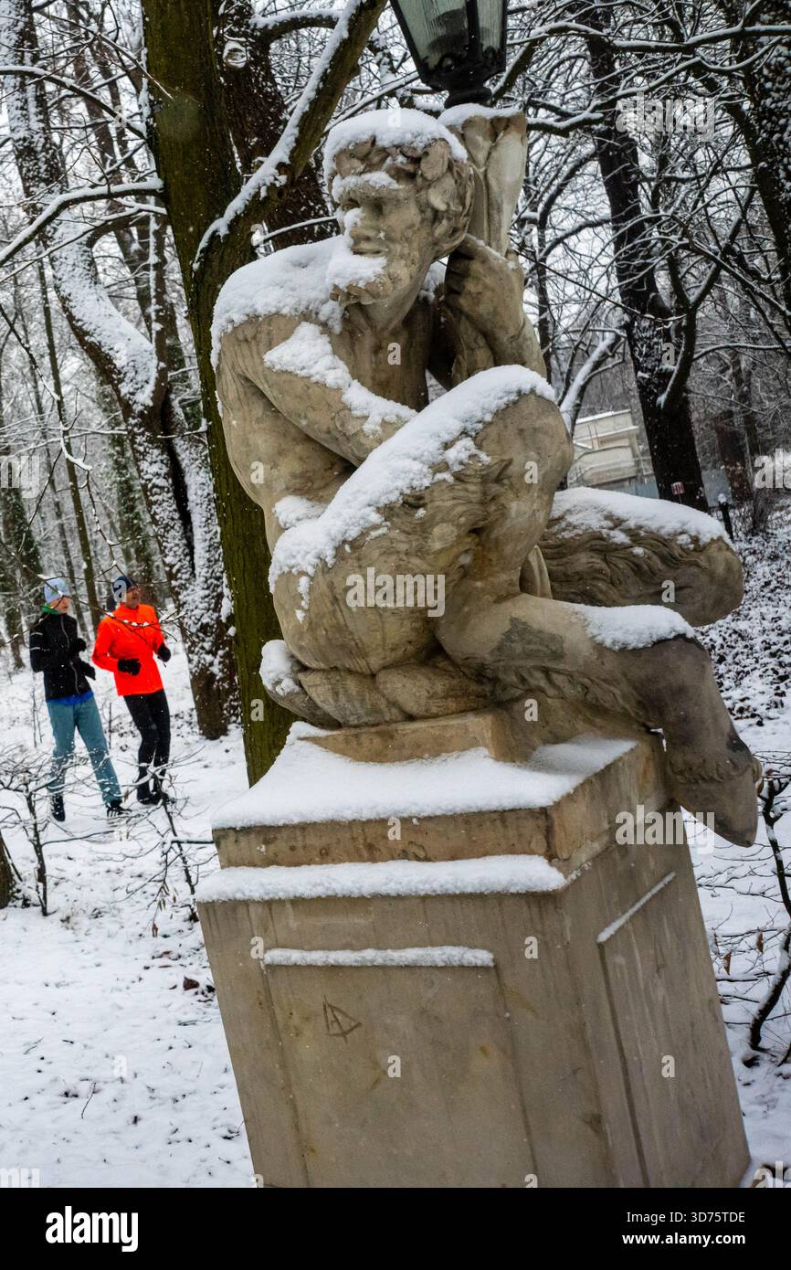 A statue of a faun is seen under freshly fallen snow as two Varsovians ...