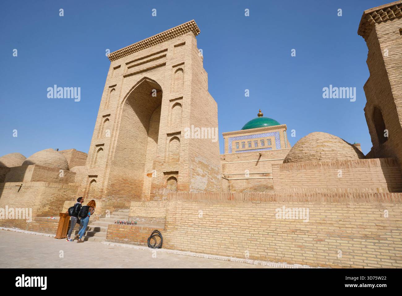 The large, tan brick archway front entrance gate to the complex ...