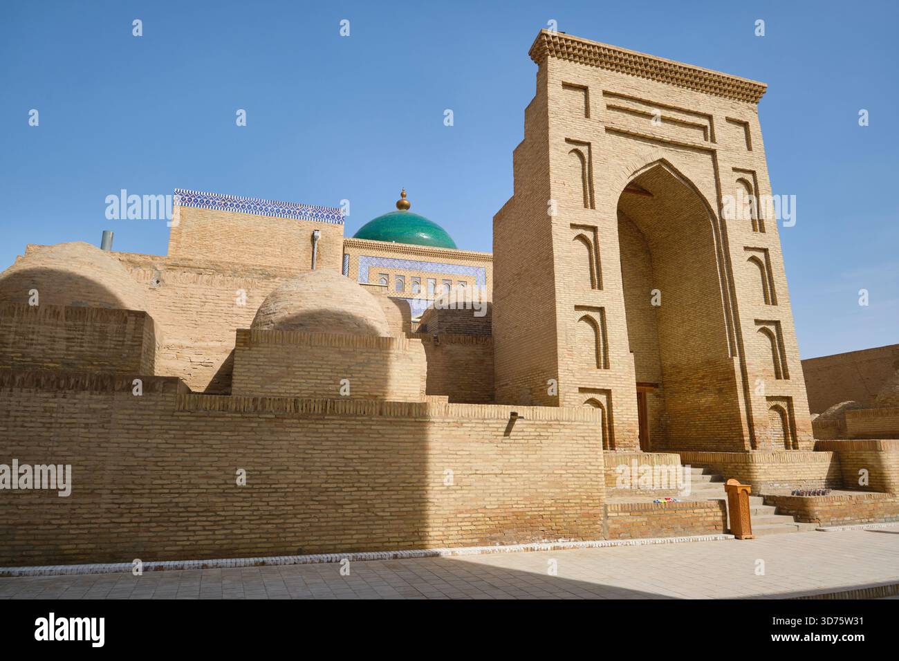 The large, tan brick archway front entrance gate to the complex ...