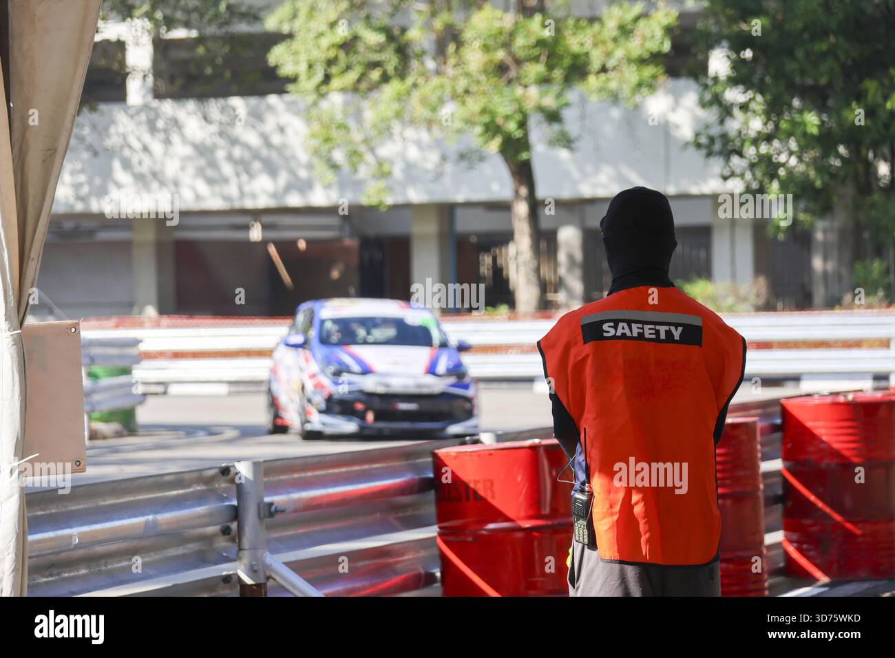 Professional safety marshal in an orange vest attentively watching race ...