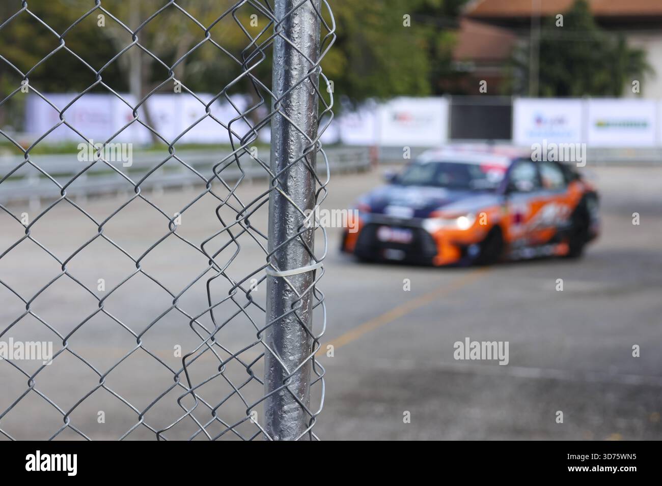 Exciting view through metal fence of race car in motion on track. speed ...