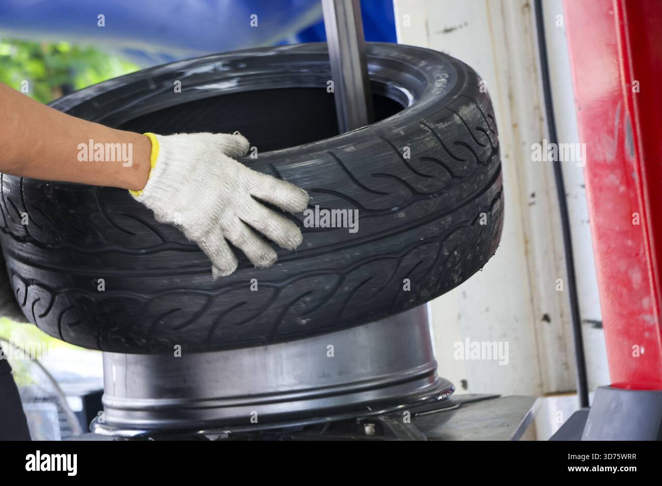 Focused mechanic changing car tire on wheel rim using machine in ...