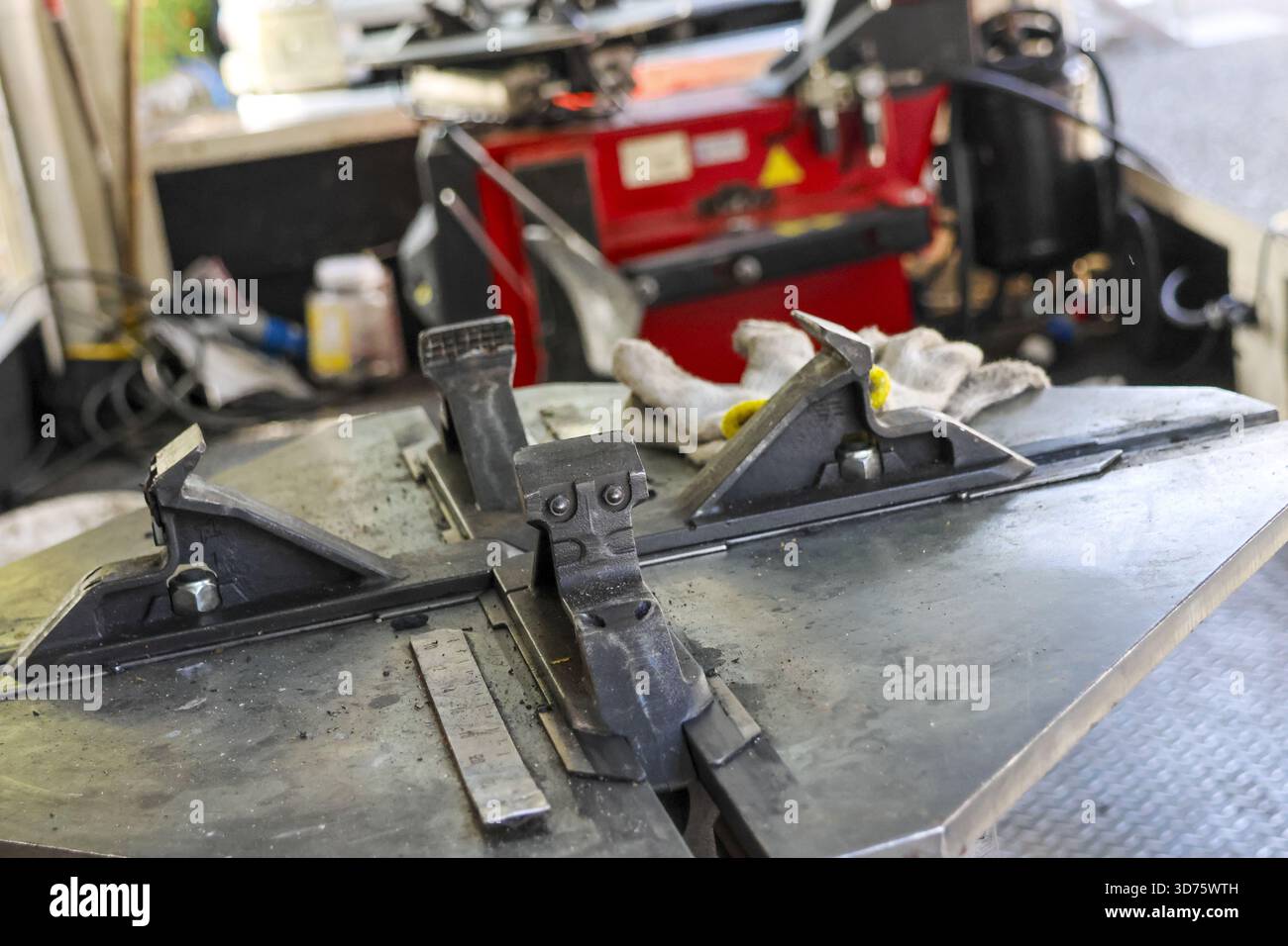 Rugged metal clamp and jig on steel workbench in workshop, ready for ...
