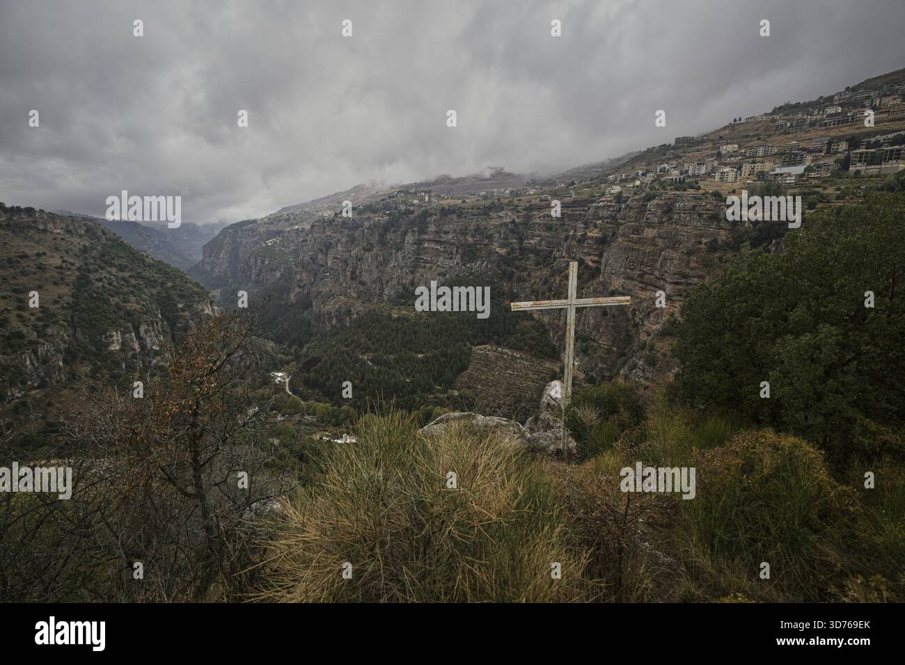 A cross stands on a cliff overlooking the Kadisha Valley, a holy site ...