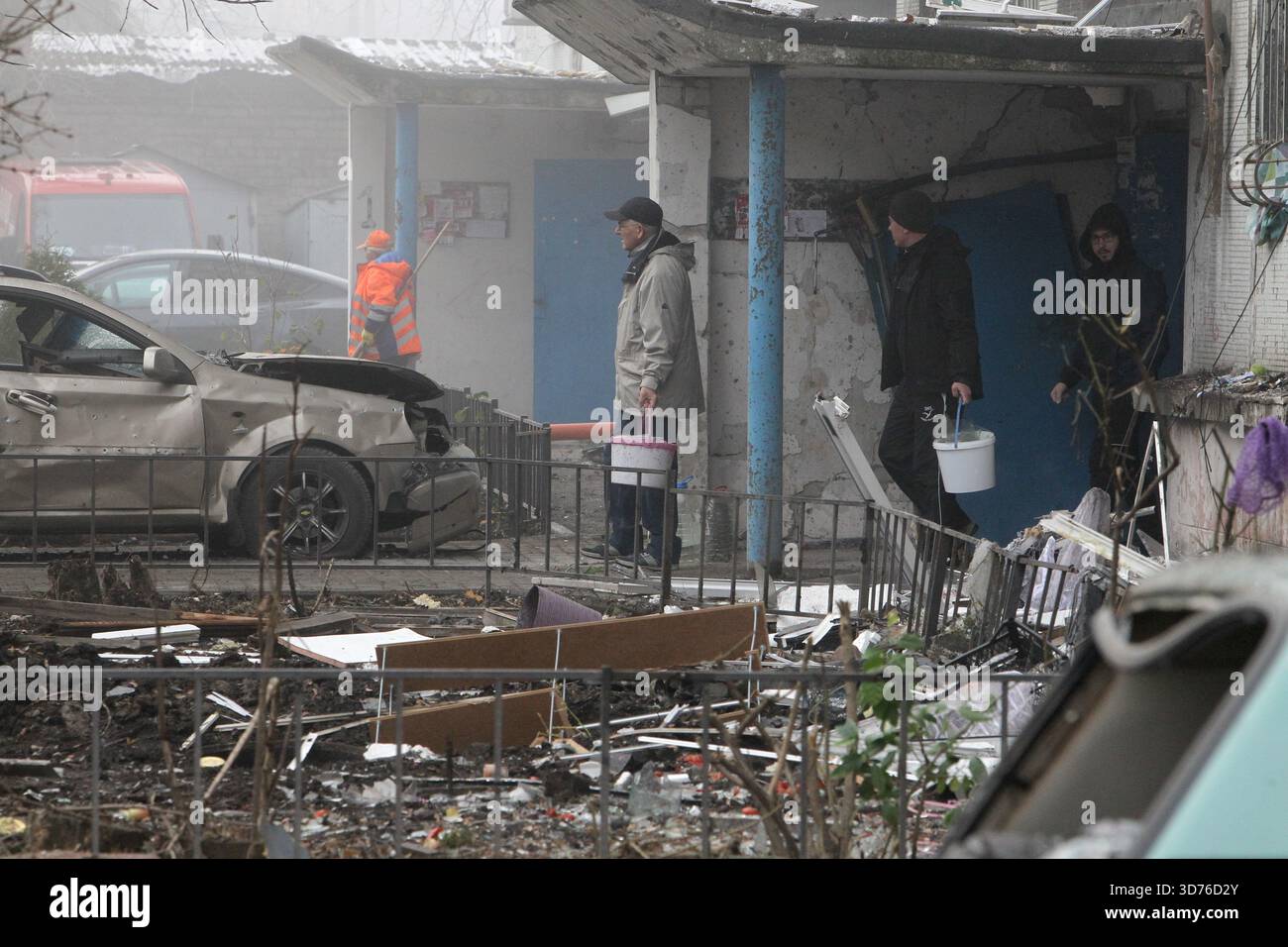 Men carry buckets with debris and glass shards out of an apartment ...