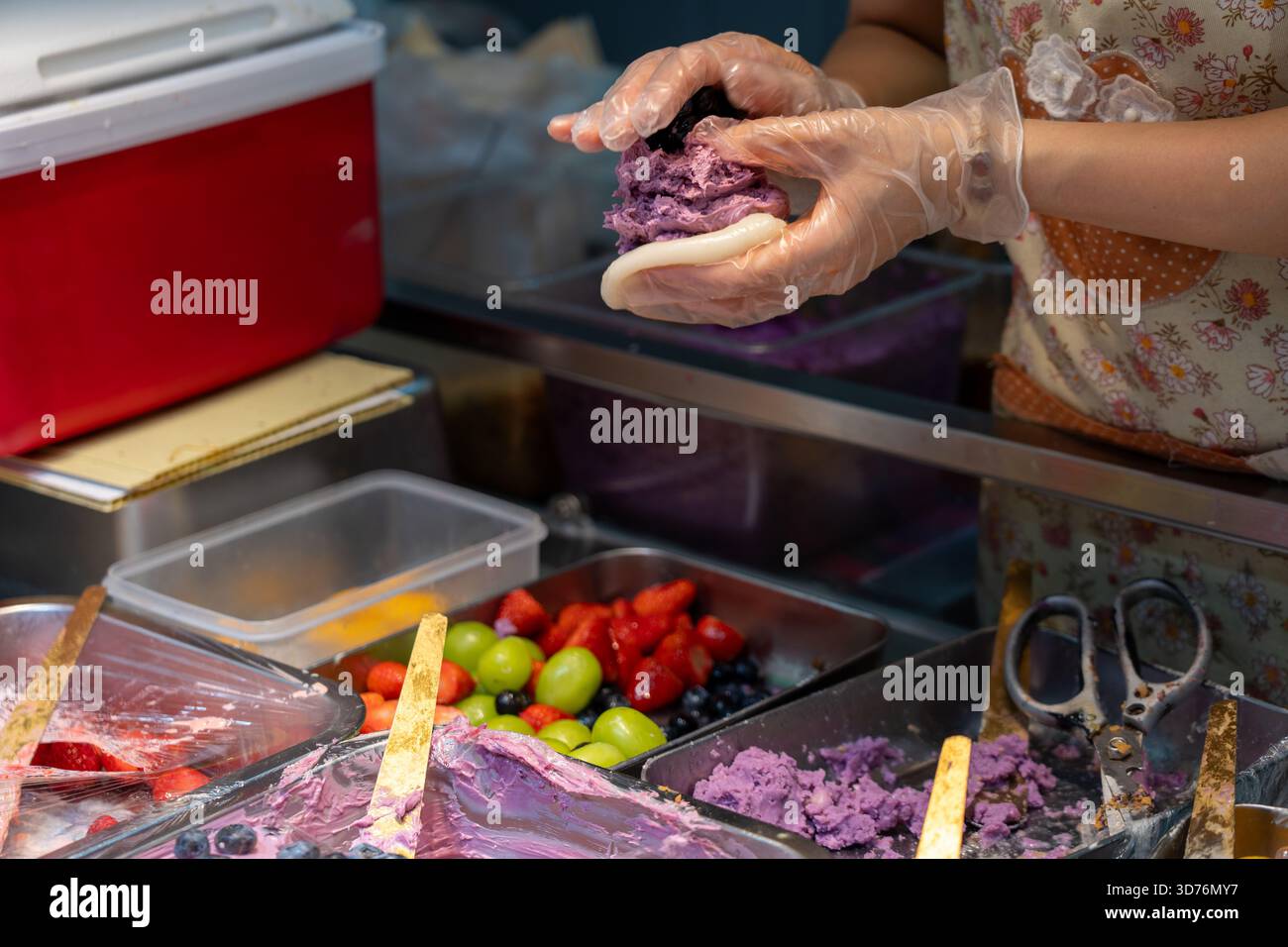 A chef wearing gloves prepares a Chinese mochi or sweet rice cake ...