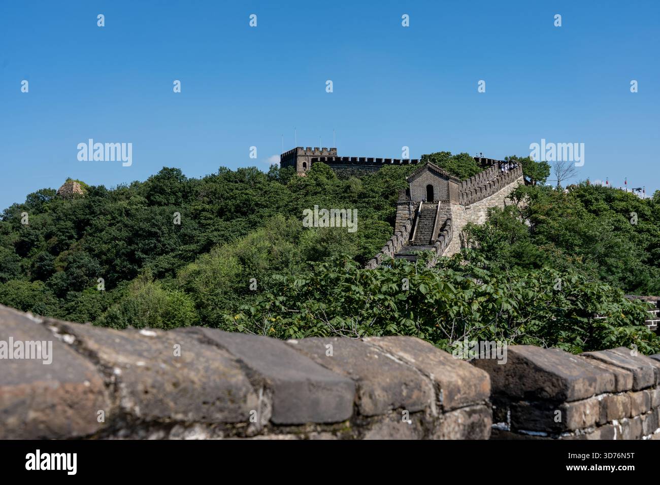 A watchtower and section of the Great Wall of China sit atop a forested ...