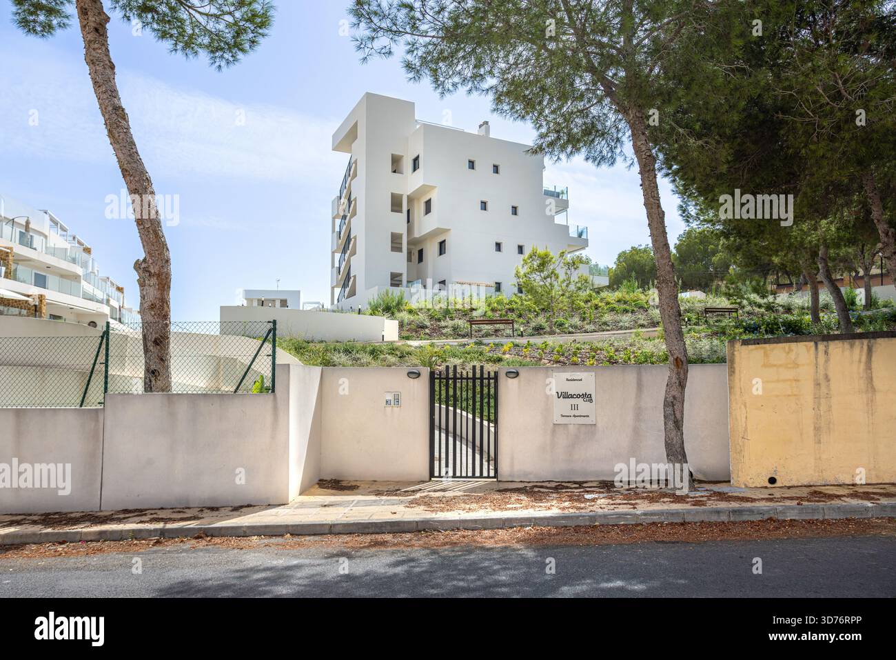 View of secured entrance to apartment complex with pathway, gardens ...