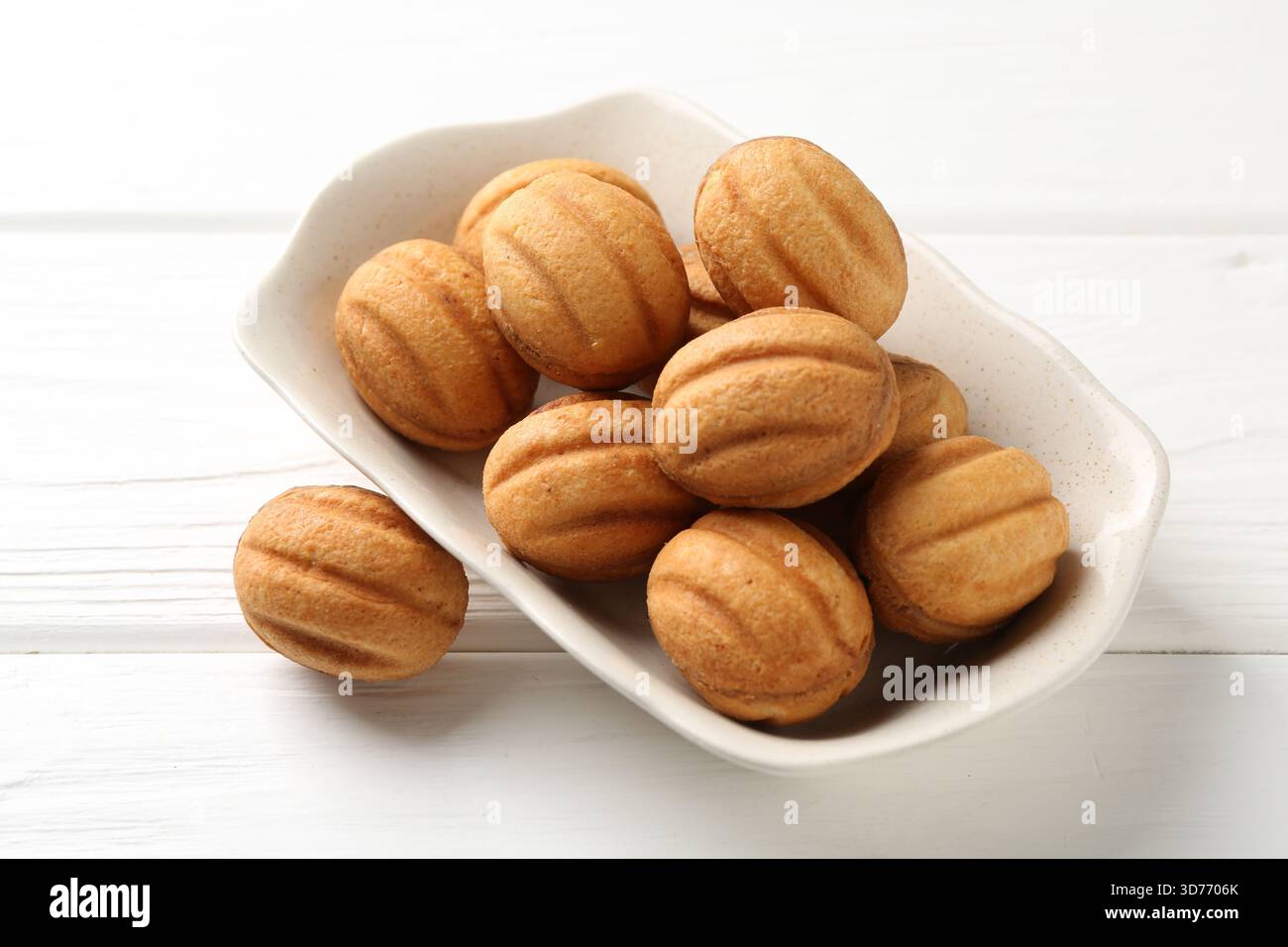 Delicious nut shaped cookies with boiled condensed milk on white wooden ...