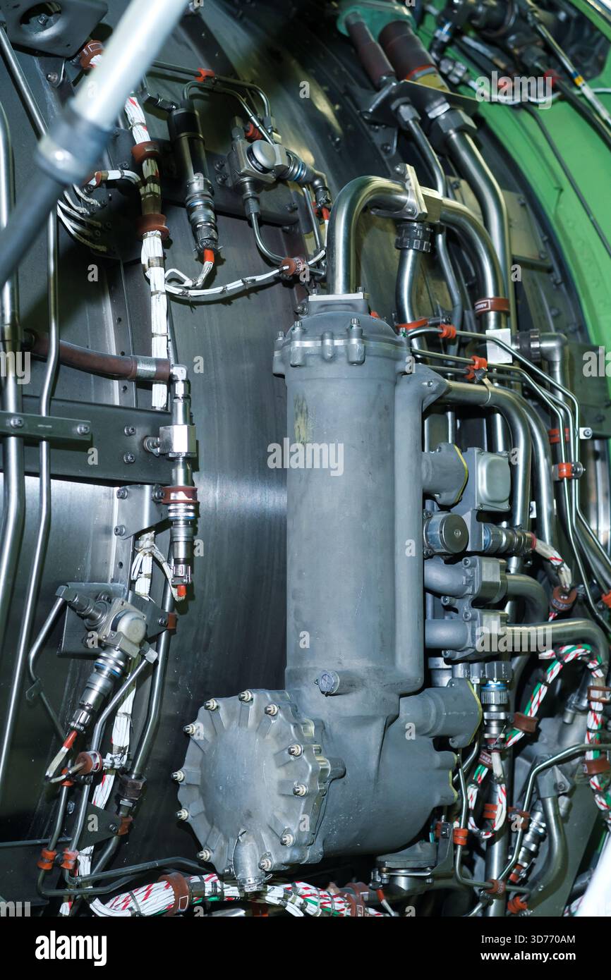 An engineer inspects complex piping and mechanical components inside an ...