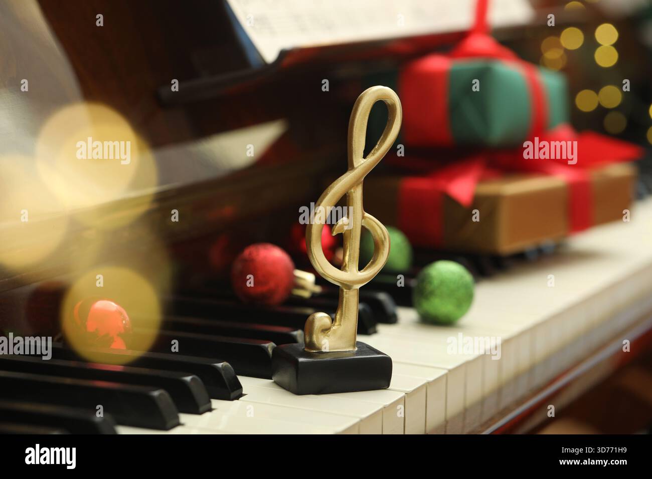 Christmas atmosphere. Golden treble clef on piano, closeup. Bokeh ...