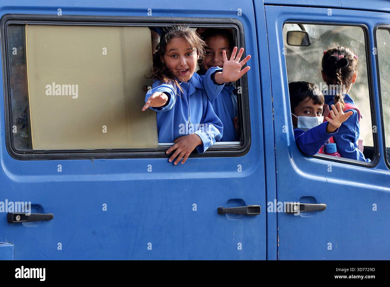 11 November 2025, Lebanon, Rmiesh: Students wave from their bus as they ...