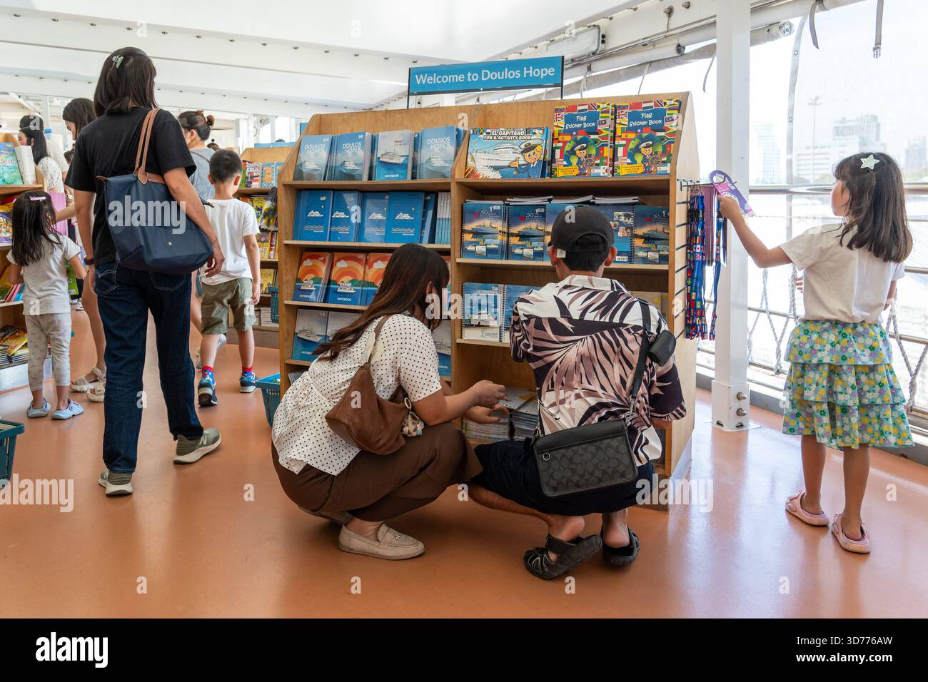 Visitors browsing books and notebooks about the Doulos Hope, on sale at ...