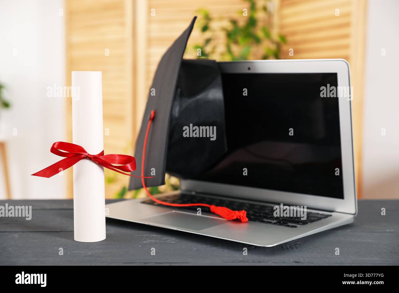 Diploma, graduation hat and laptop on grey wooden table indoors Stock ...