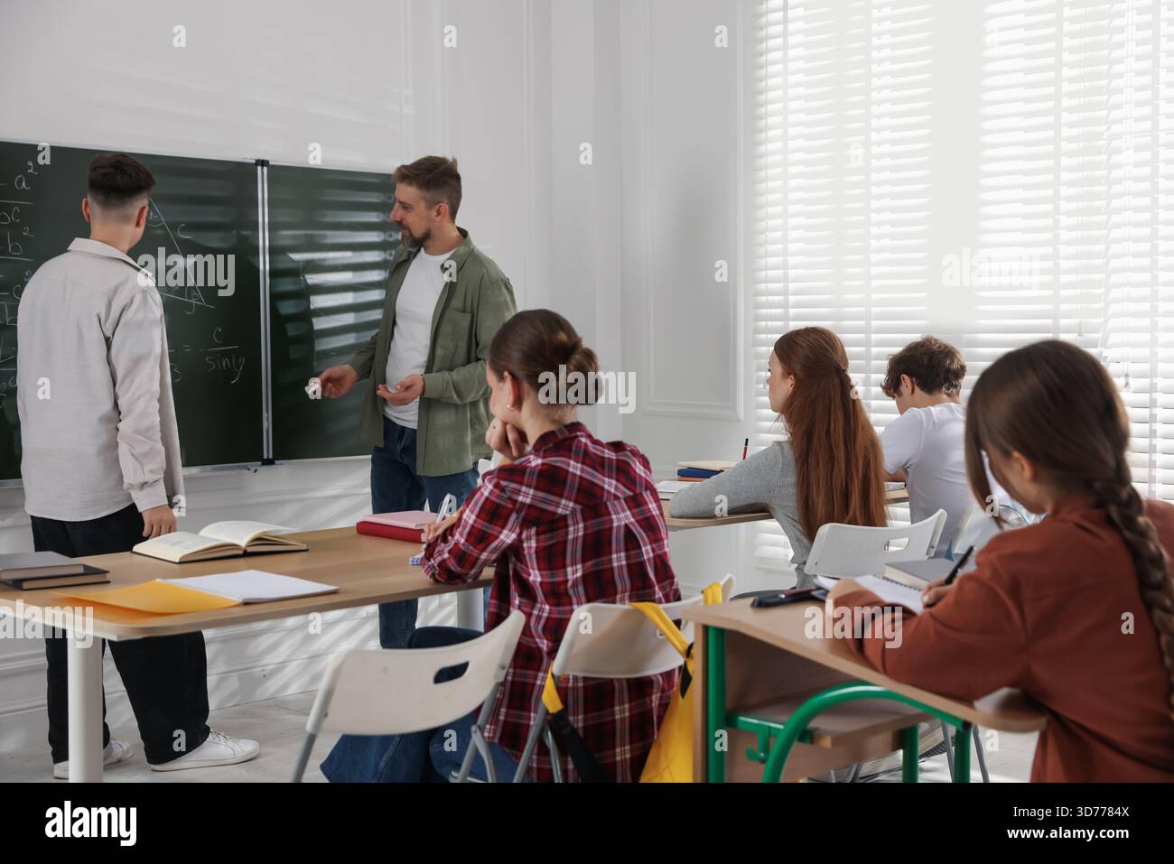 Teacher and students during lesson in classroom Stock Photo - Alamy