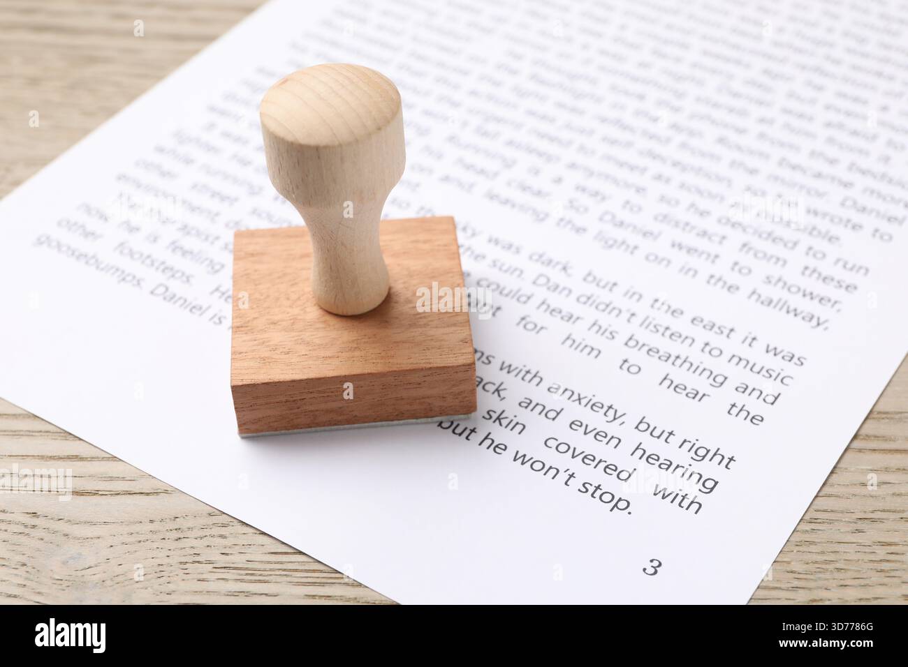 One wooden stamp and sheet of paper with text on table, closeup Stock ...