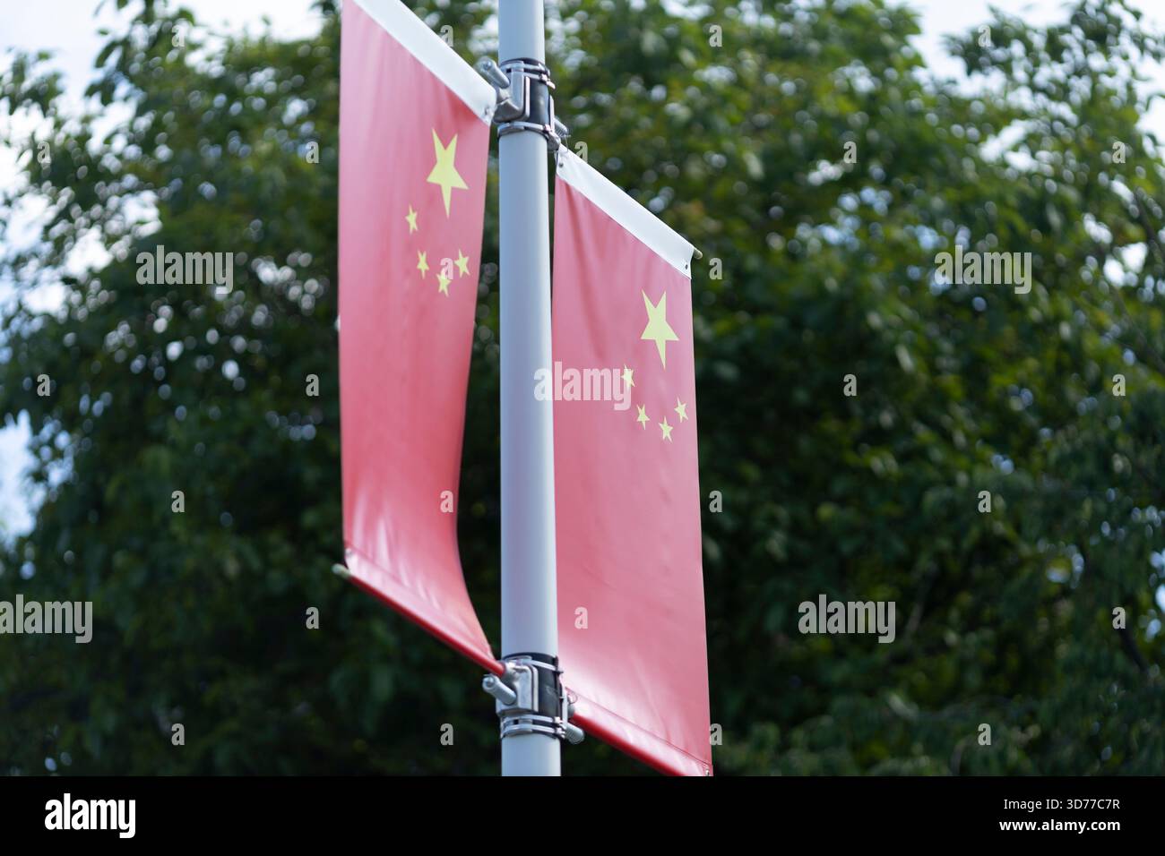 Two chinese flags displayed on a pole Stock Photo - Alamy