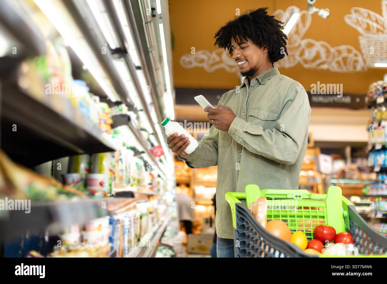 Man Shopping in Grocery Store Looking at Products and Using Phone for ...
